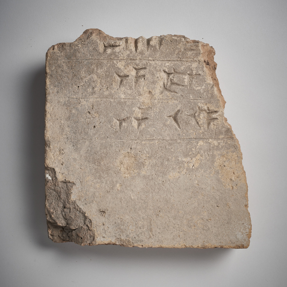A FRAGMENTARY ASSYRIAN CLAY CUNEIFORM BRICK