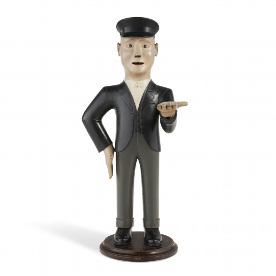 A CARVED AND PAINTED TRAIN CONDUCTOR FIGURE