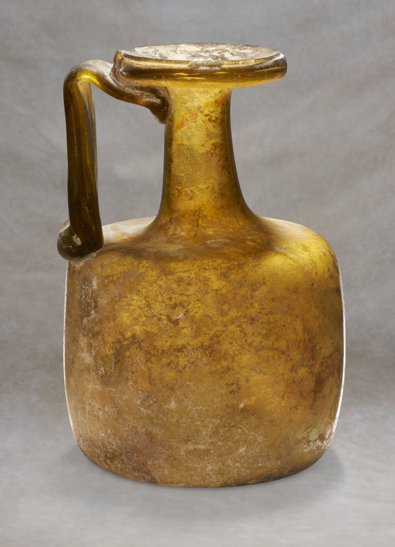 A ROMAN AMBER GLASS JUG